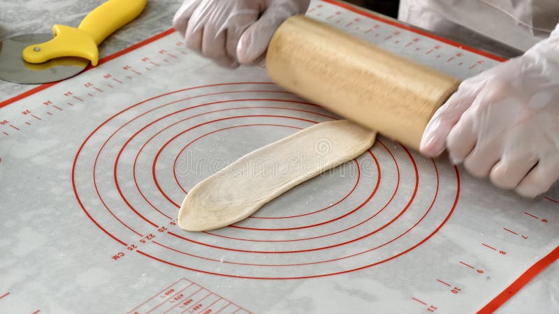 The Dough is Being Rolled Flat with a Rolling Pin for Making Bread ...