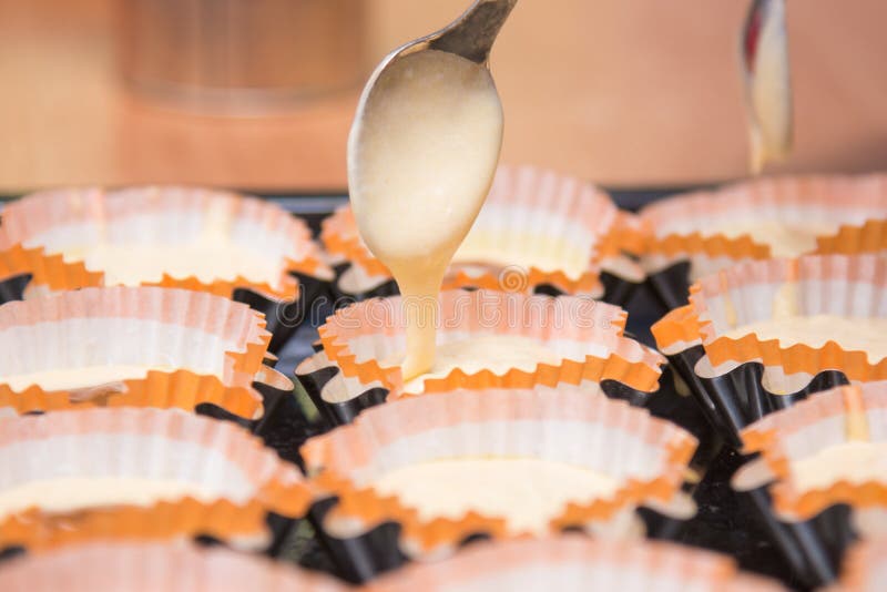 Dough for Cakes Dripping from a Spoon into Molds Stock Photo - Image of ...