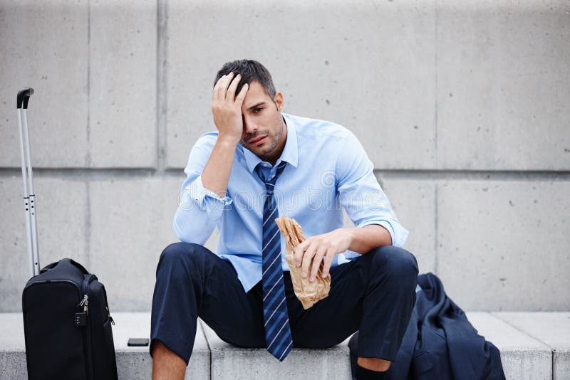 Down on His Luck. a Young Businessman Sitting Outdoors and Drinking ...