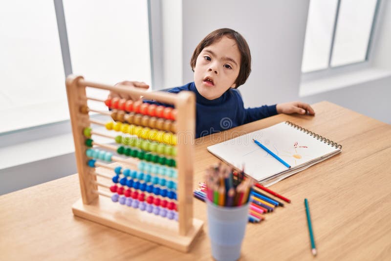 Down Syndrome Kid Drawing on Notebook at School Stock Photo - Image of ...