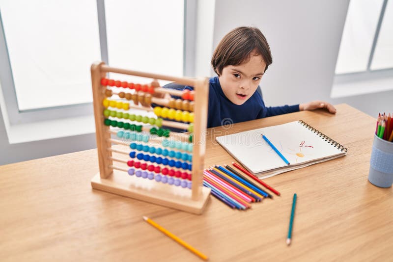 Down Syndrome Kid Drawing on Notebook at School Stock Image - Image of ...