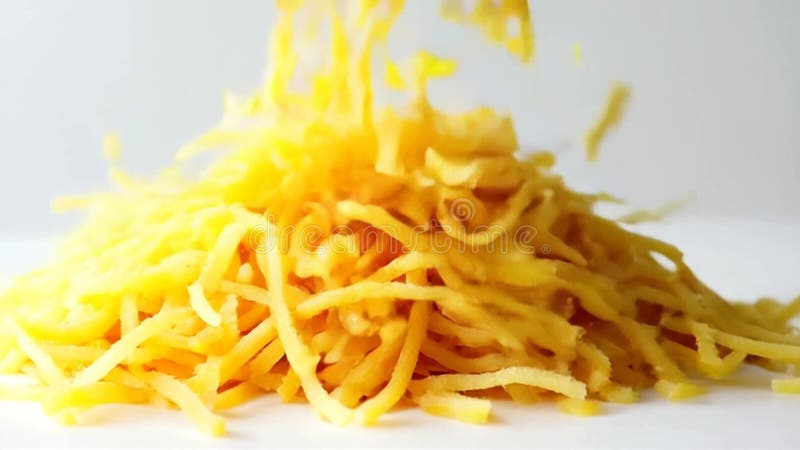 Downward Shot of Shredded Yellow Cheddar Cheese Falling Against Clean ...