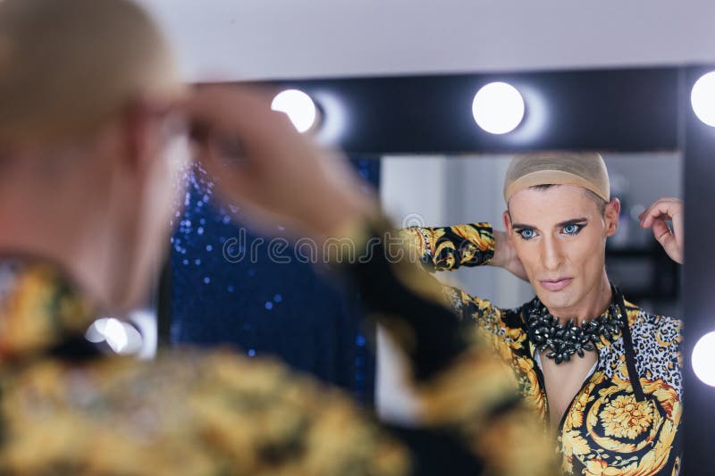Drag Queen Putting on a Wig Facing a Mirror in Backstage Stock Photo ...