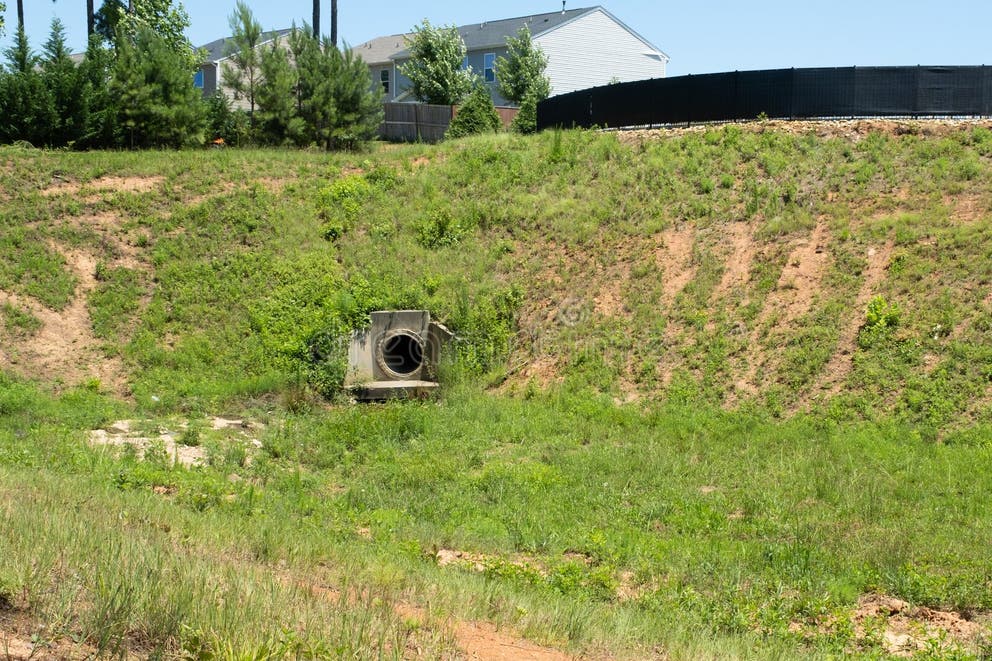 Drainage Ditch Lined with Grass and Weeds Behind a Subdivision Stock ...