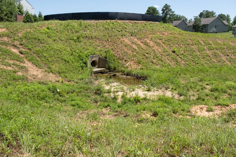 Drainage Ditch Lined with Grass and Weeds Behind a Subdivision Stock ...