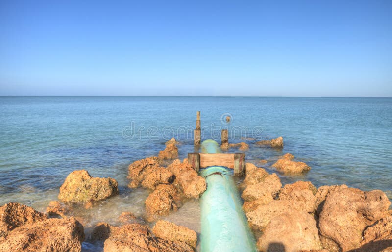 Beach drainage pipe stock photo. Image of blue, pebbles - 53537406