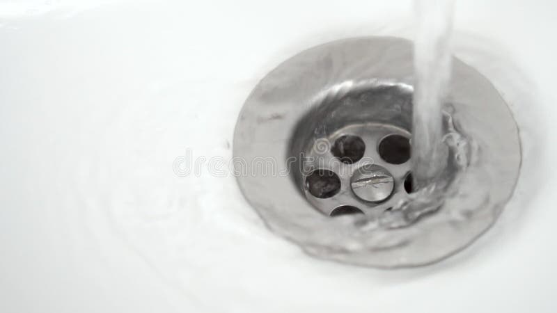 Rainage of a Stream of Drinking Water in a White Sink. Slow Motion ...