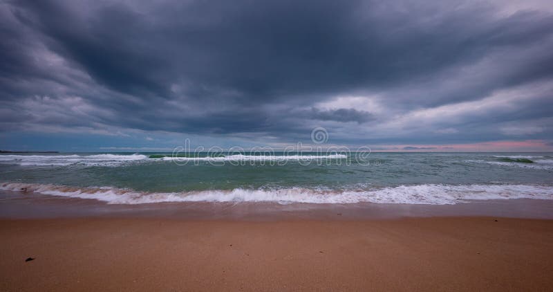 Dramatic Beach Shoreline and Sea Under a Cloudy Sky Dark Clouds with ...