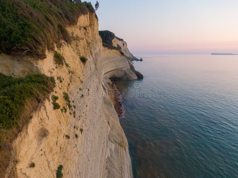 Dramatic Cliffside at Sunset with Serene Ocean View Stock Image - Image ...