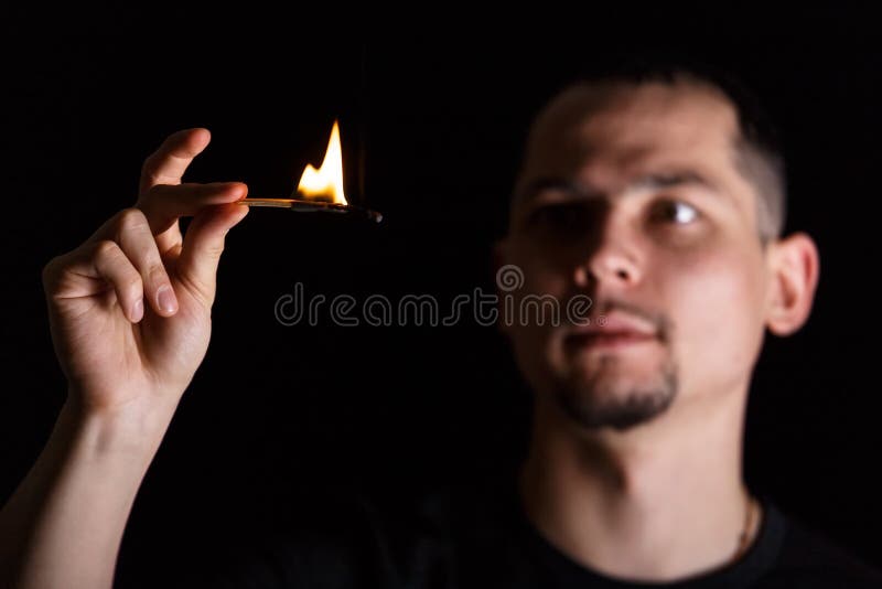 Dramatic Dark Portrait of Man and Lit Match Fire Over Black Background ...
