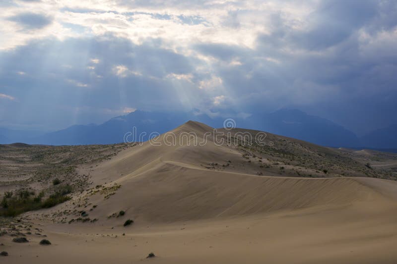 Dramatic Desert Dunes Under Sunbeams and Cloudy Sky Stock Photo - Image ...