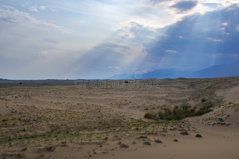 Dramatic Desert Dunes Under Sunbeams and Cloudy Sky Stock Photo - Image ...