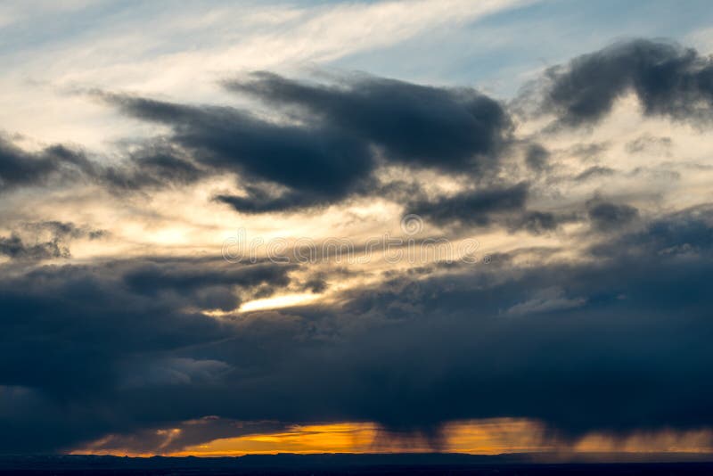 Dramatic Even Clouds with Snow Showers Falling Out and Orange Sk Stock ...
