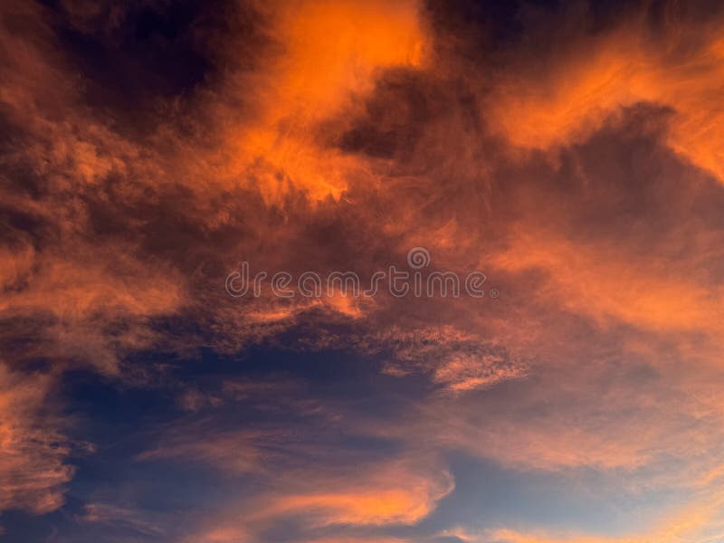 Dramatic Fiery Clouds Against a Deep Blue Sky at Sunset or Sunrise ...