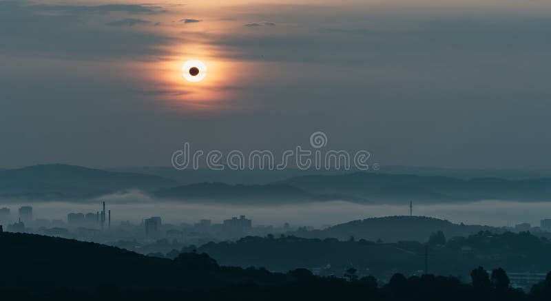 A Dramatic Landscape Features a Solar Eclipse with the Sun Partially ...