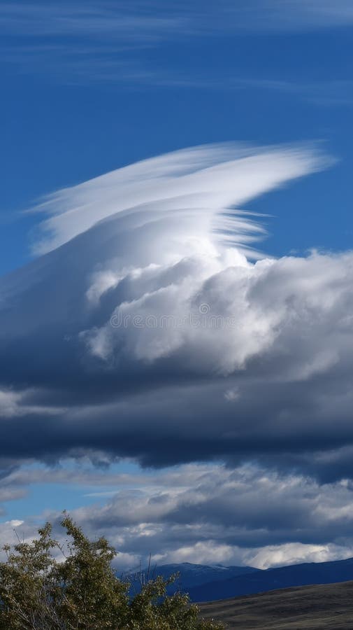Dramatic Lenticular Clouds Form Over Mountains in a Sunny Blue Sky ...