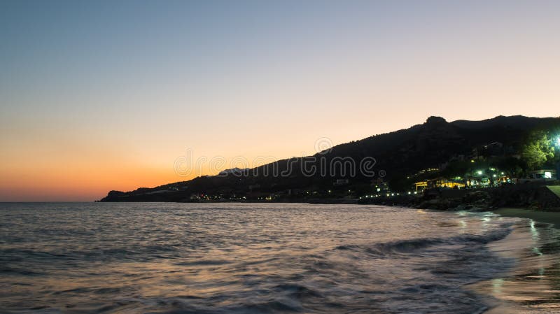 Sea Shore at the Sunset with Mountains Behind and Little Waves Stock ...