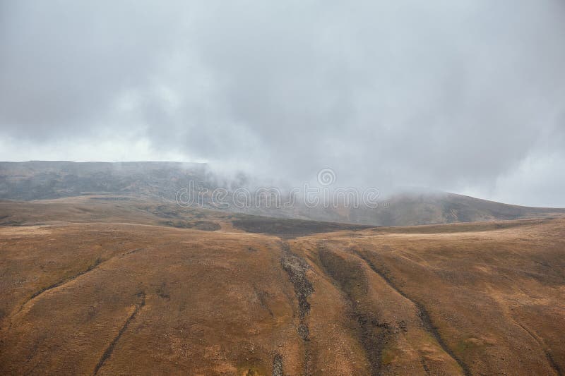 Dramatic Mountain Valley Under a Cloudy Sky with a Rugged Landscape ...