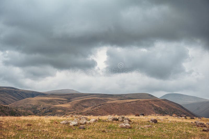 Dramatic Mountain Valley Under a Cloudy Sky with a Rugged Landscape ...