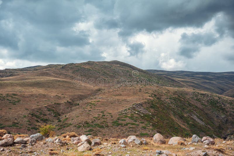 Dramatic Mountain Valley Under a Cloudy Sky with a Rugged Landscape ...