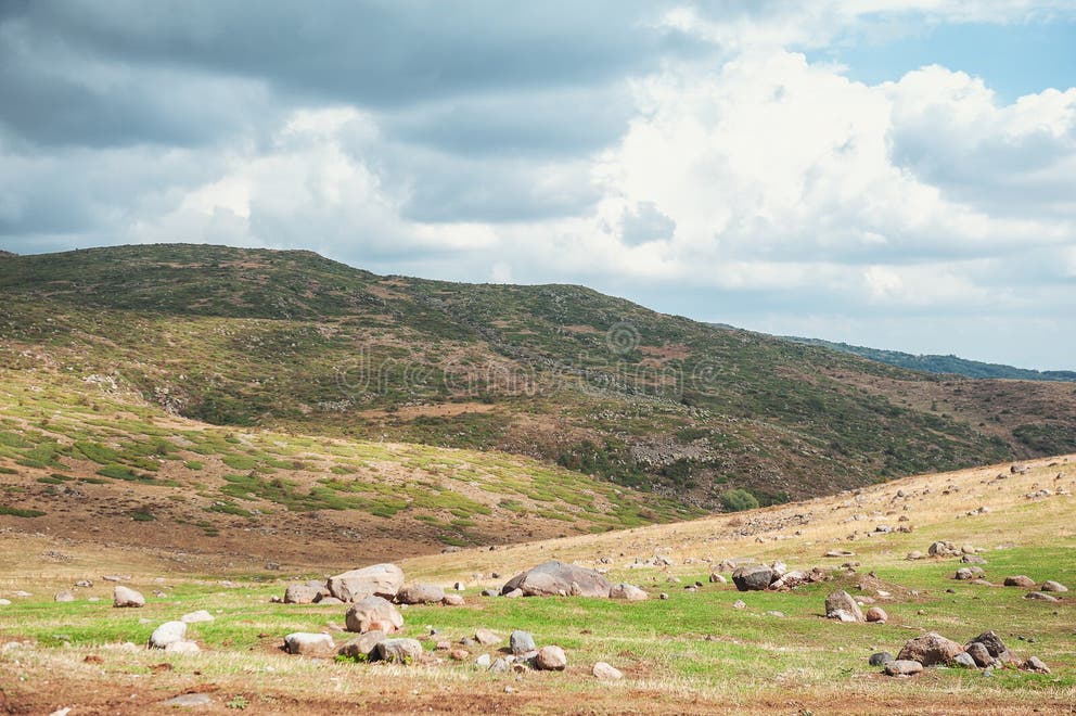 Dramatic Mountain Valley Under a Cloudy Sky with a Rugged Landscape ...
