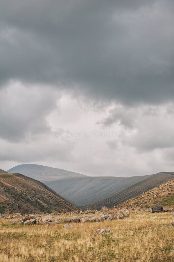 Dramatic Mountain Valley Under a Cloudy Sky with a Rugged Landscape ...