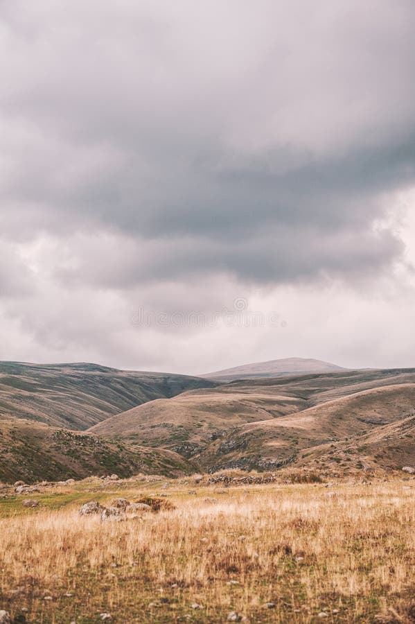Dramatic Mountain Valley Under a Cloudy Sky with a Rugged Landscape ...