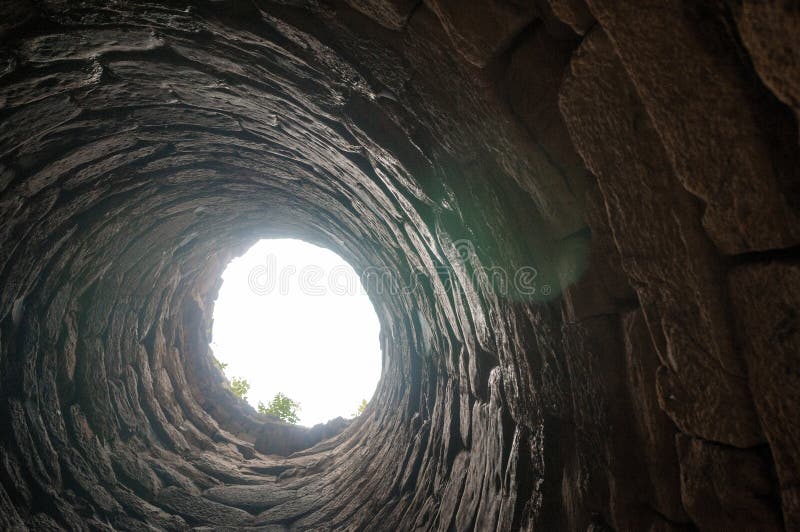 A Dramatic Perspective of an Ancient Stone Well Reaching Towards the ...