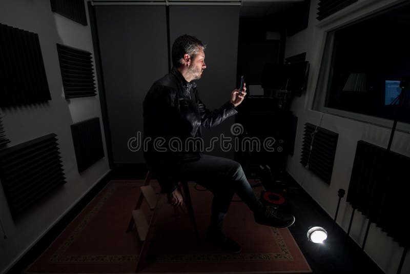 Dramatic Portrait of a Guy Looking at a Cell Phone. Stock Image - Image ...