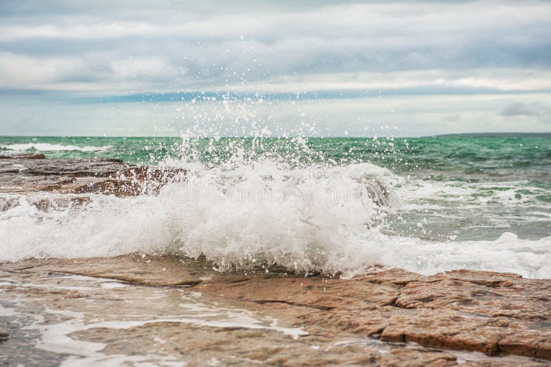 Dramatic Scene with Sea Waves, Rocky Seashore and Clouds Stock Photo ...