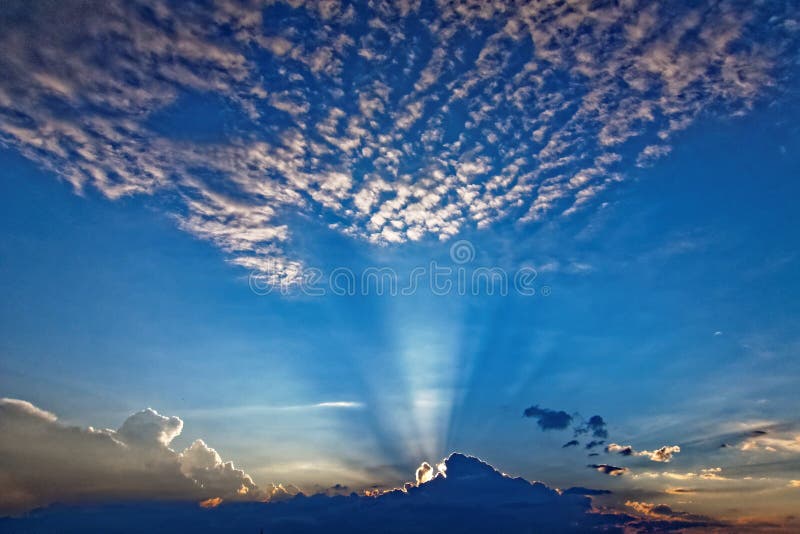 Sunbeams from Below Shine Upwards into a Clouded Sky at Sunset Stock ...