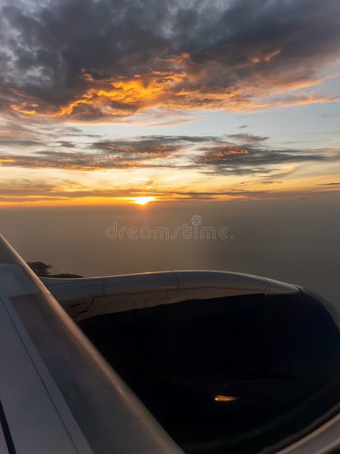Flying Aerial through Plane Window Over Wing To Colored Sky and and ...
