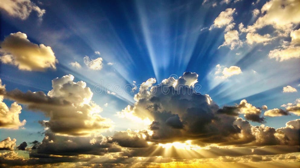 A Dramatic Sky with Sun Rays Bursting through Clouds Stock Photo ...