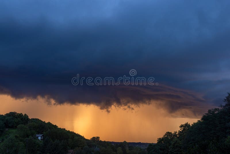 Dramatic Storm Clouds with an Intense Rain Lit by the Setting Sun Stock ...