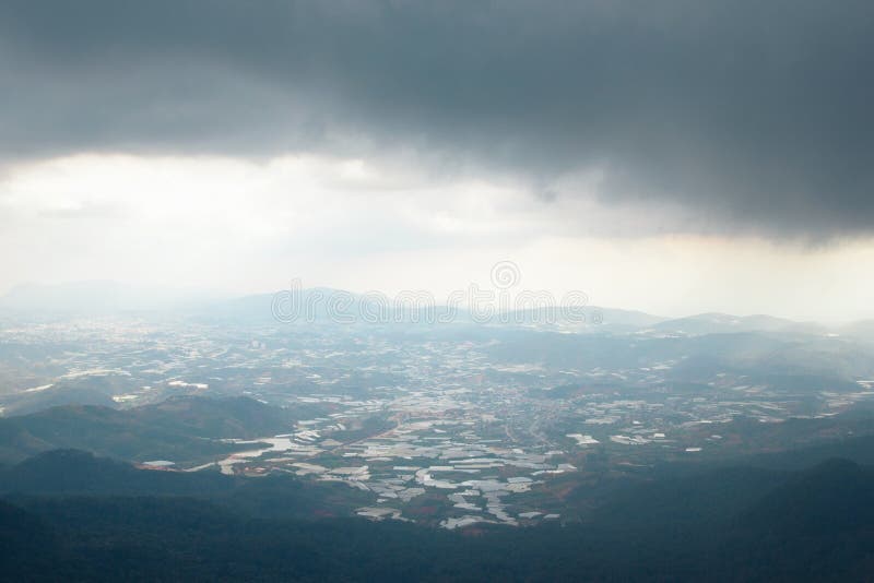 Dramatic Storm Clouds Over Misty Valley Landscape with Distant ...