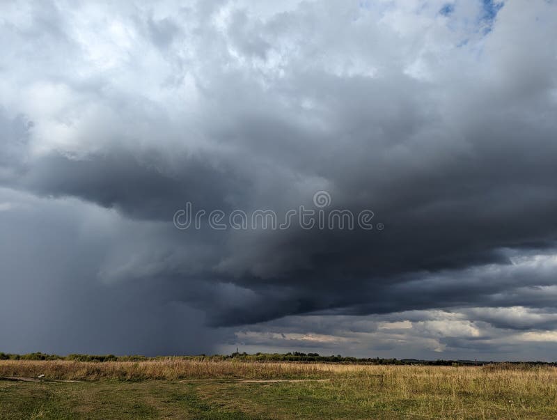 A Dramatic Stormy Sky Looms Over an Open Field, Creating an Engaging and Captivating Scene Stock ...