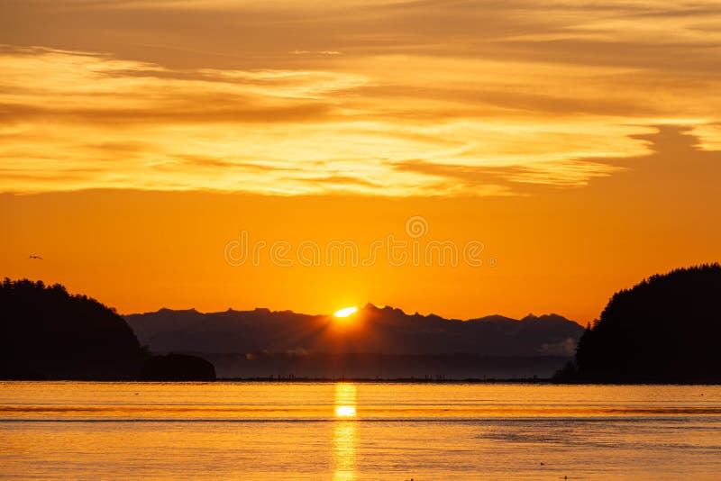 Dramatic Sun Rising between Two Hills with Water Stock Photo - Image of ...