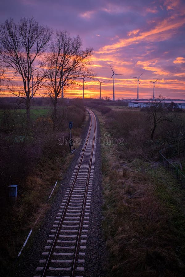 A Dramatic Sunrise Colors the Sky Purple and in the Foreground Railroad ...