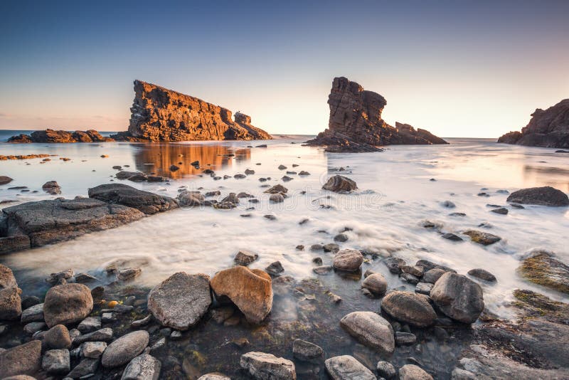 Dramatic Sunrise with Mist on the Beach with Rocks Stock Photo - Image ...