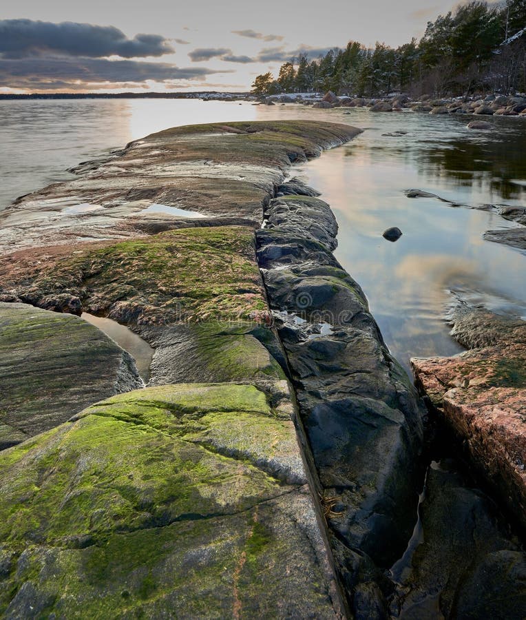 Dramatic Sunset Over a Rocky Shoreline, with Seaweed-covered Rocks ...