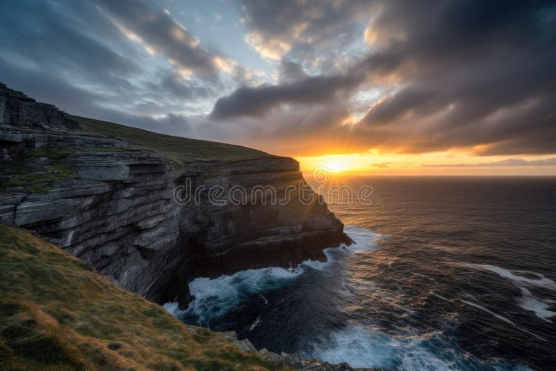 Dramatic Sunset Over a Rugged Coastal Cliff, with the Sun Peeking Out ...