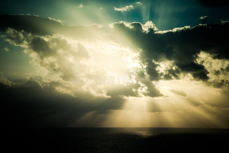 Dramatic Sunset Rays Through A Cloudy Dark Sky Over The Ocean Stock ...