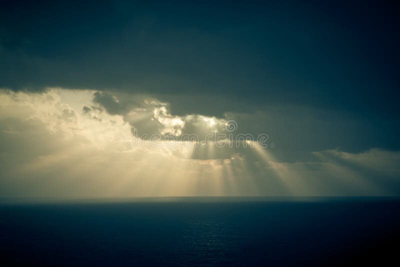 Dramatic Sunset Rays through a Cloudy Dark Sky Over the Ocean Stock ...