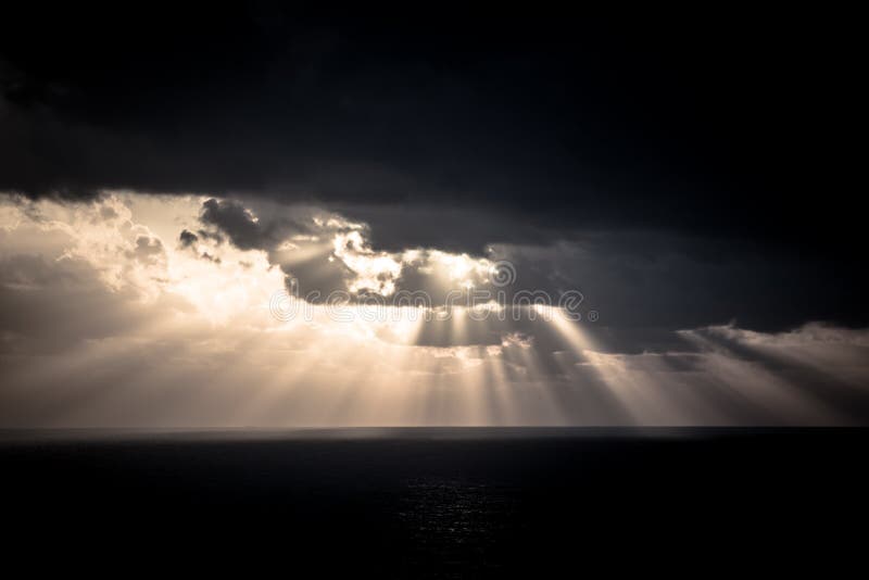 Dramatic Sunset Rays through a Cloudy Dark Sky Over the Ocean Stock ...