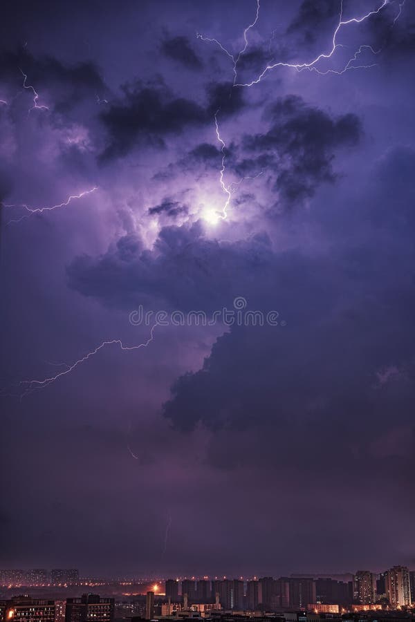 A Storm with Lightnings and Some Clouds Over Buildings with Lights in ...