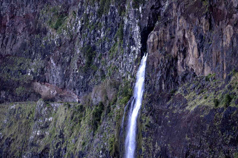 A Dramatic Waterfall Cascading Down a Rugged Cliff Covered in Moss and ...