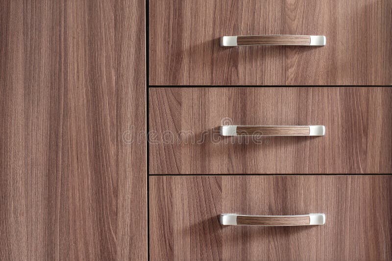 Drawer Pulls with Silver Metal Handles in Front of a Wooden Cabinet in ...