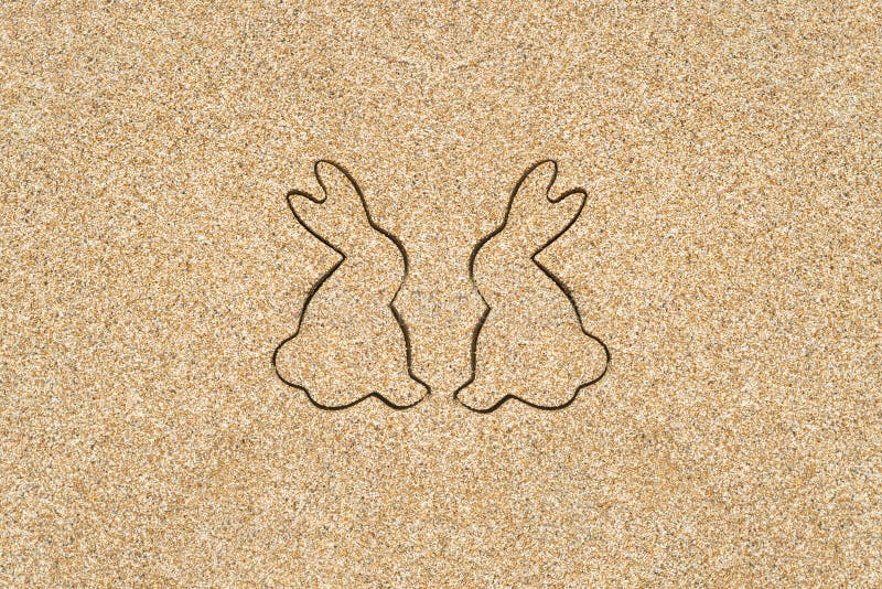 Drawing Creative Two Easter Bunny on the Sand on the Beach. Stock Image ...