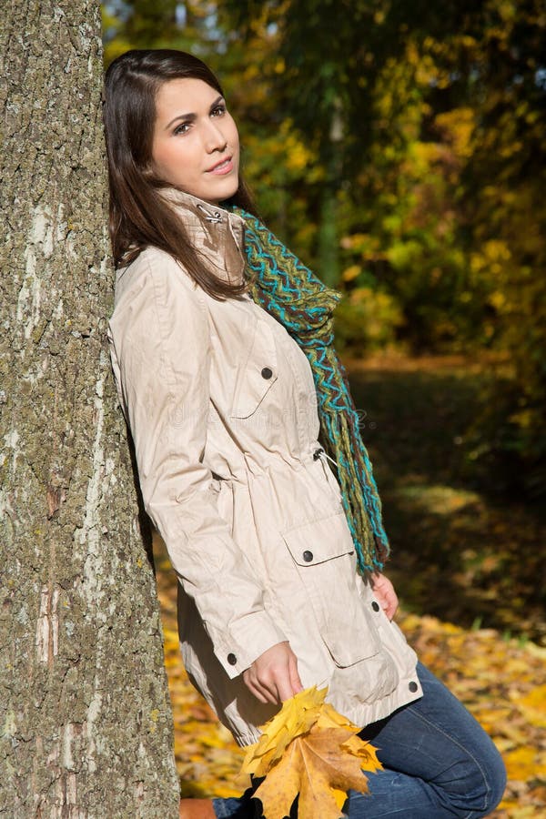 Dreaming Young Woman Leaning on a Tree Trunk in Fall. Stock Photo ...