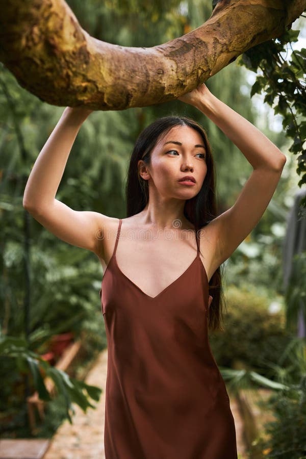 Dreamy Young Brunette Woman Posing Beside Tree On The Tropical Beach